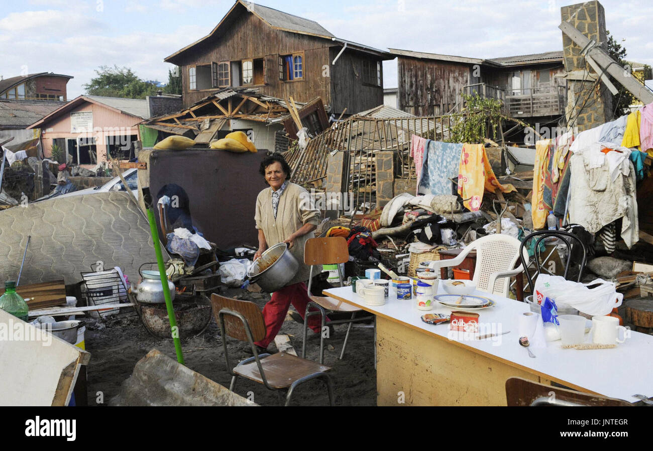 CONCEPCION, Chile - A woman prepares breakfast in front of her damaged ...
