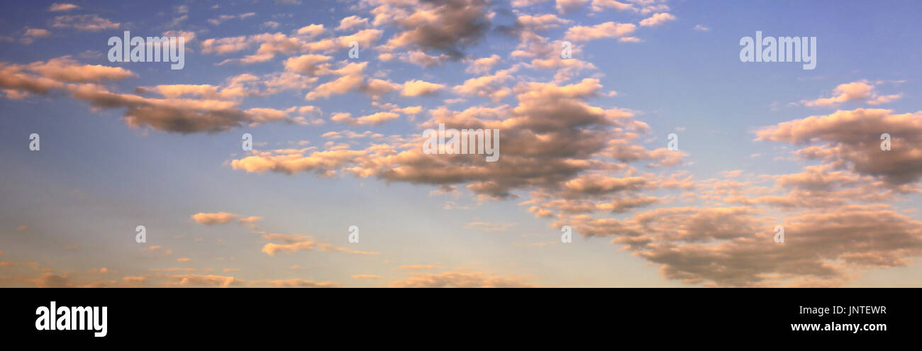 Simple blue sky background with clouds at sunset Stock Photo - Alamy