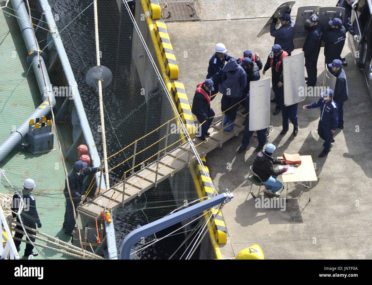 YOKOHAMA, Japan - Peter Bethune (wearing hood) boards the whaling fleet ...