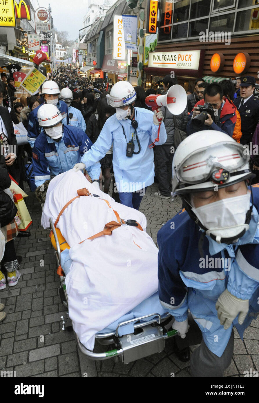 TOKYO, Japan - Emergency services personnel carry a person on a ...