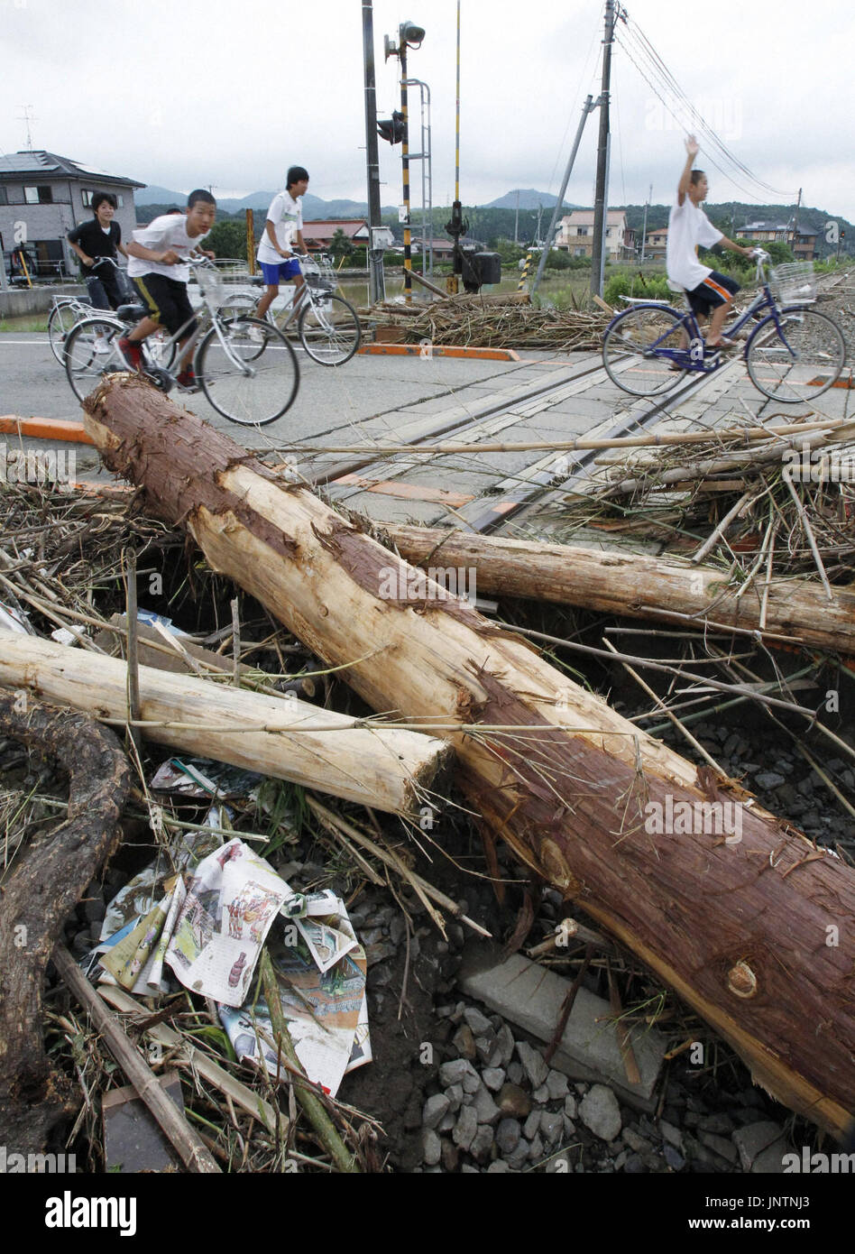 SANYO-ONODA, Japan - Children bicycle past debris on the track of the JR Mine Line in Sanyo ...