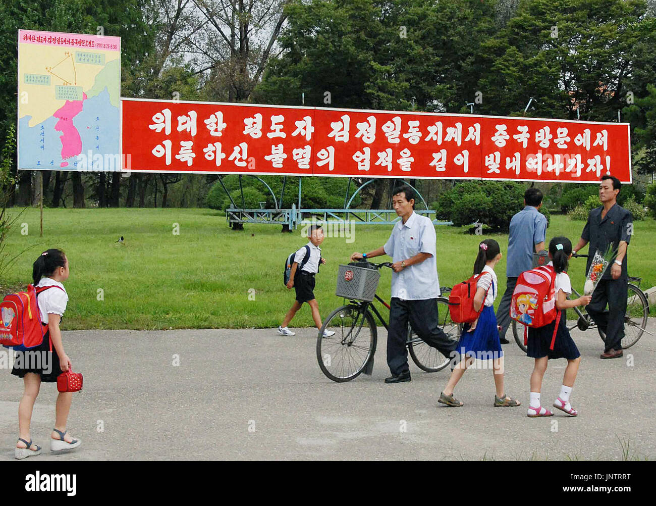 PYONGYANG, North Korea - School students walk past a signboard in ...