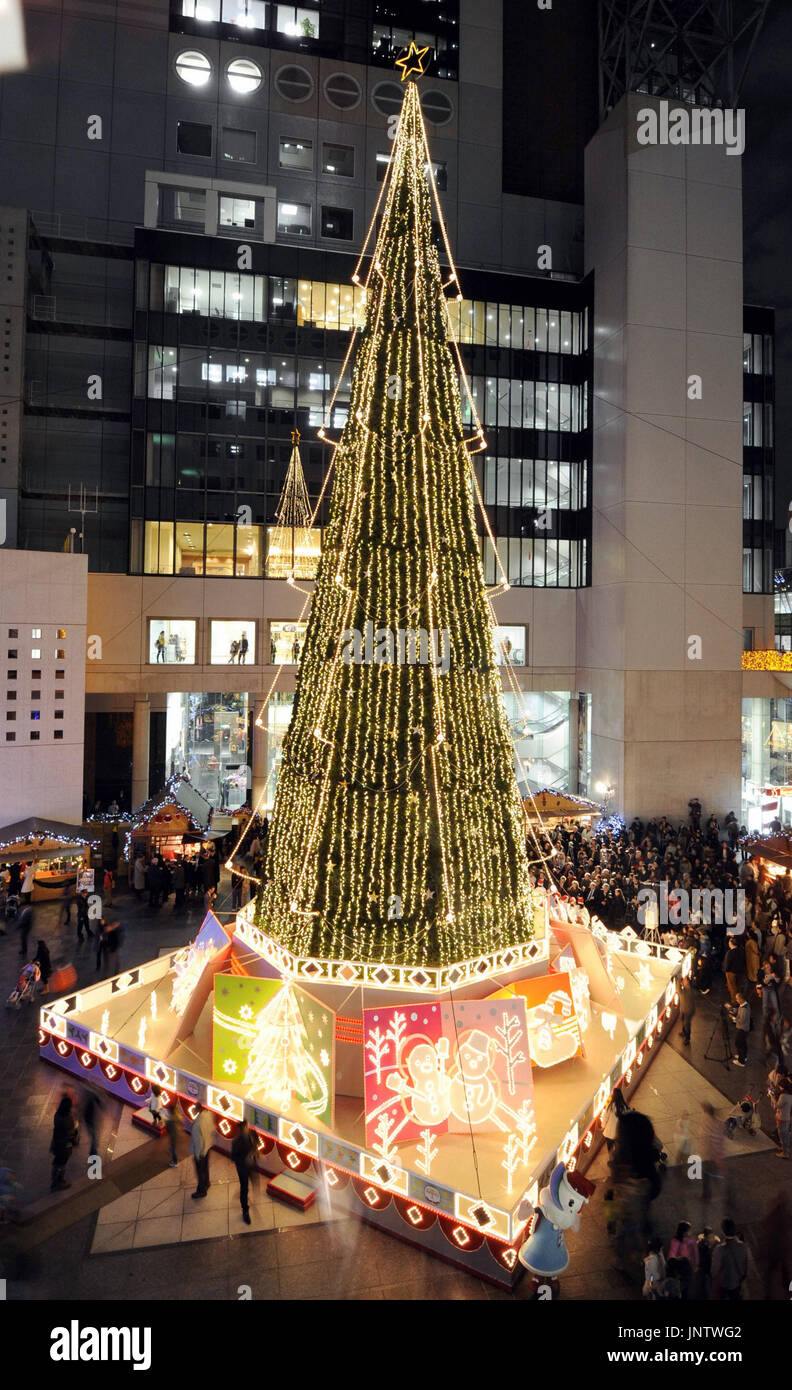 OSAKA, Japan - People admire a 27-meter-high Christmas tree illuminated ...