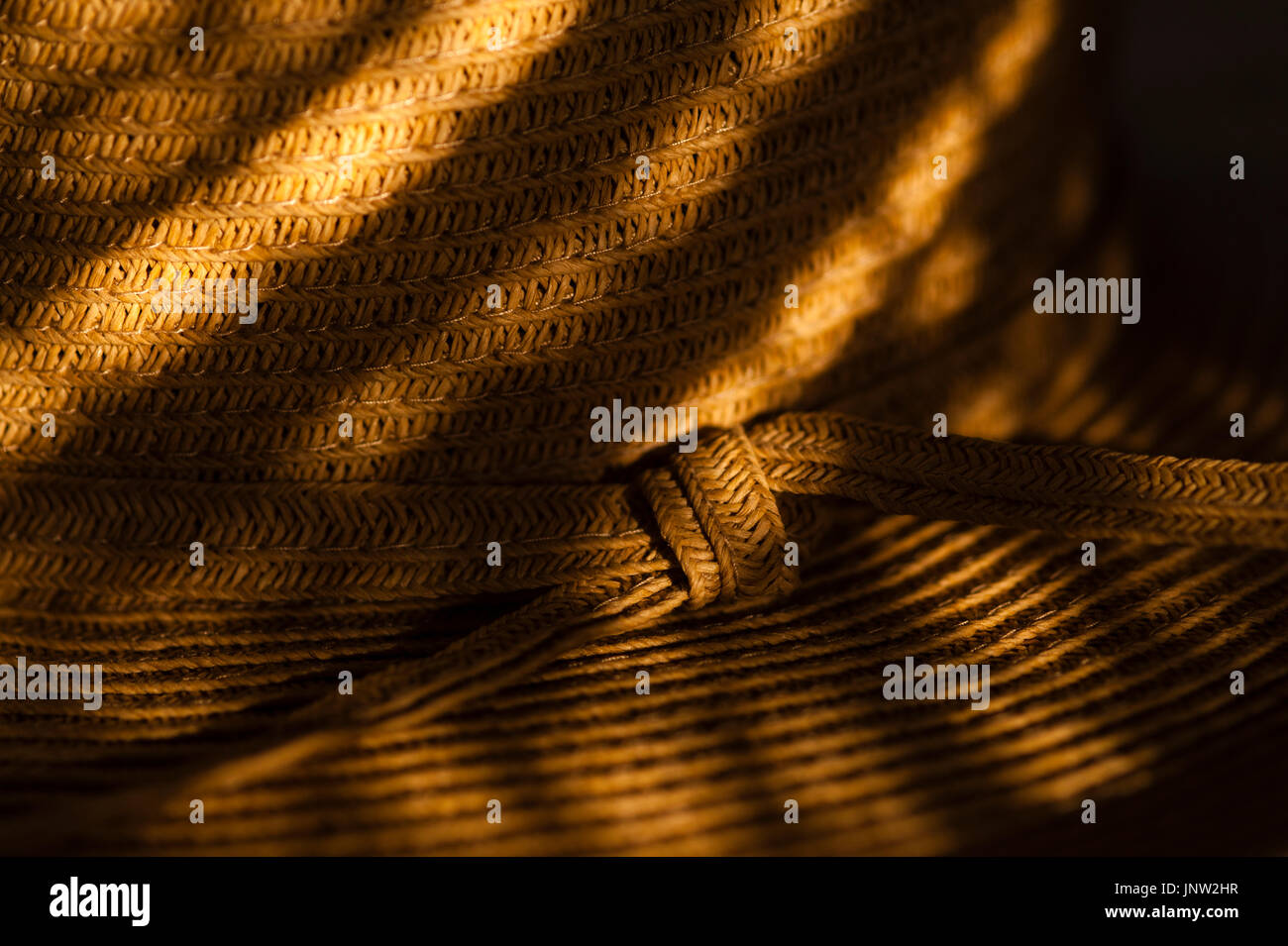 Sun hat in sunrise light on table with light streaks and close up of ...