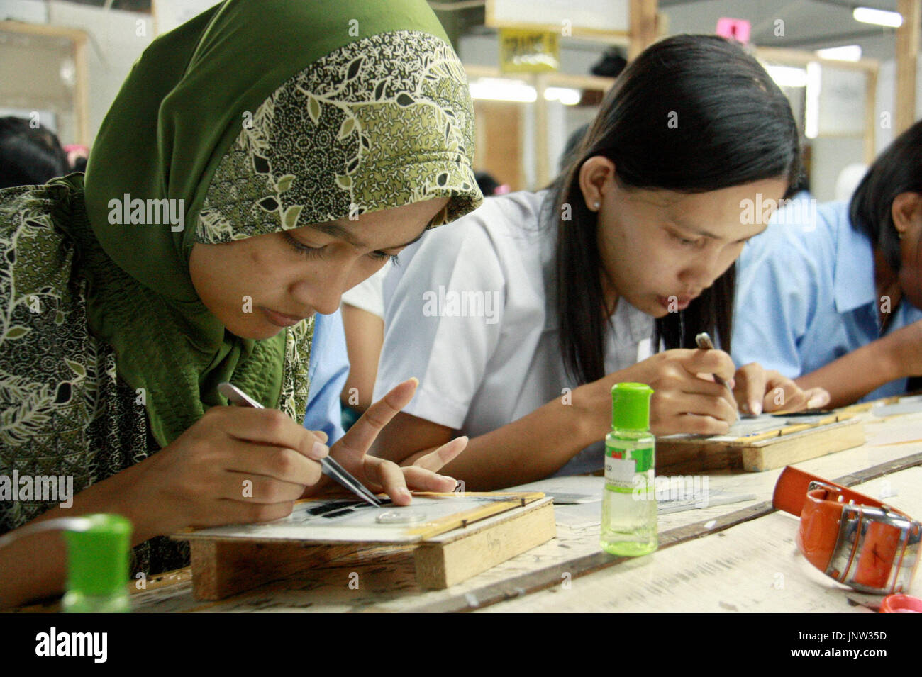 PURBALINGGA, Indonesia - Female workers carefully handle artificial ...
