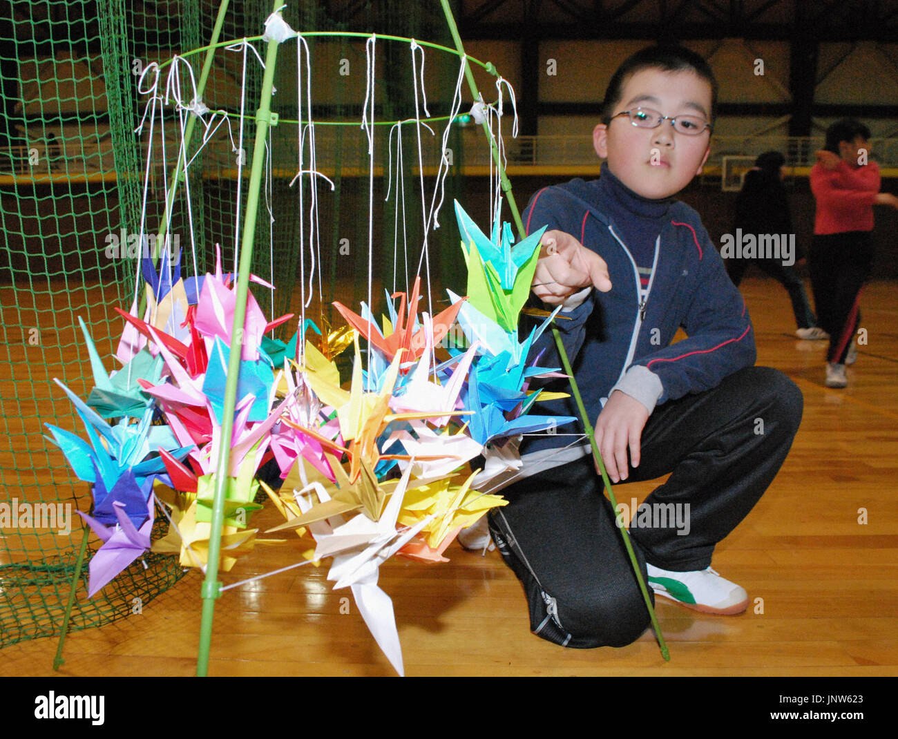 TOYAMA, Japan - Yuki Hattori, 11, looks at paper cranes, a symbol of hope and peace in Japan ...