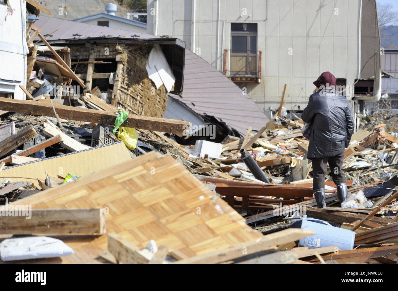 MIYAKO, Japan - A woman stands amidst the rubble of flattened buildings ...
