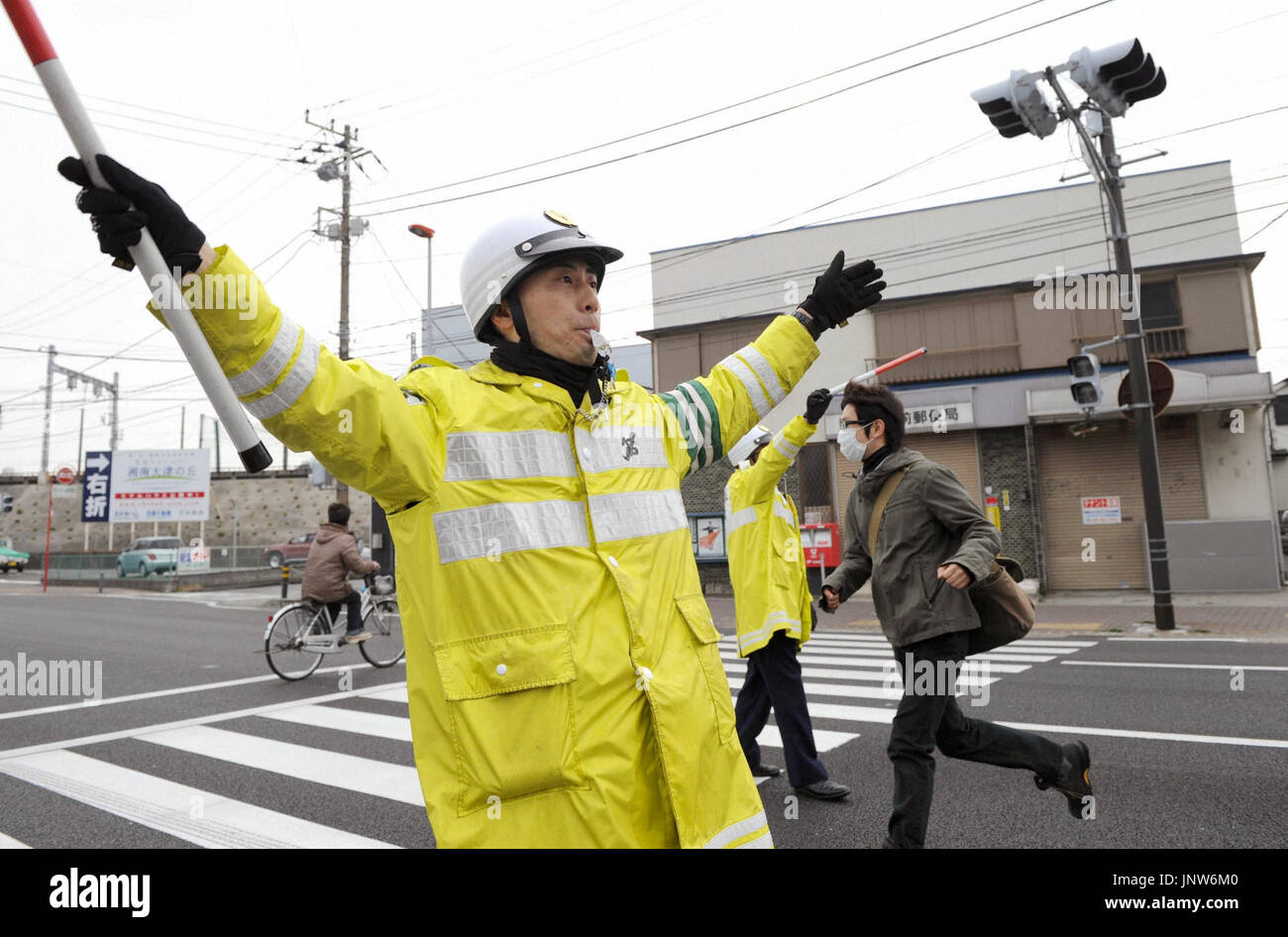 YOKOSUKA, Japan - Police officers direct traffic at an intersection ...