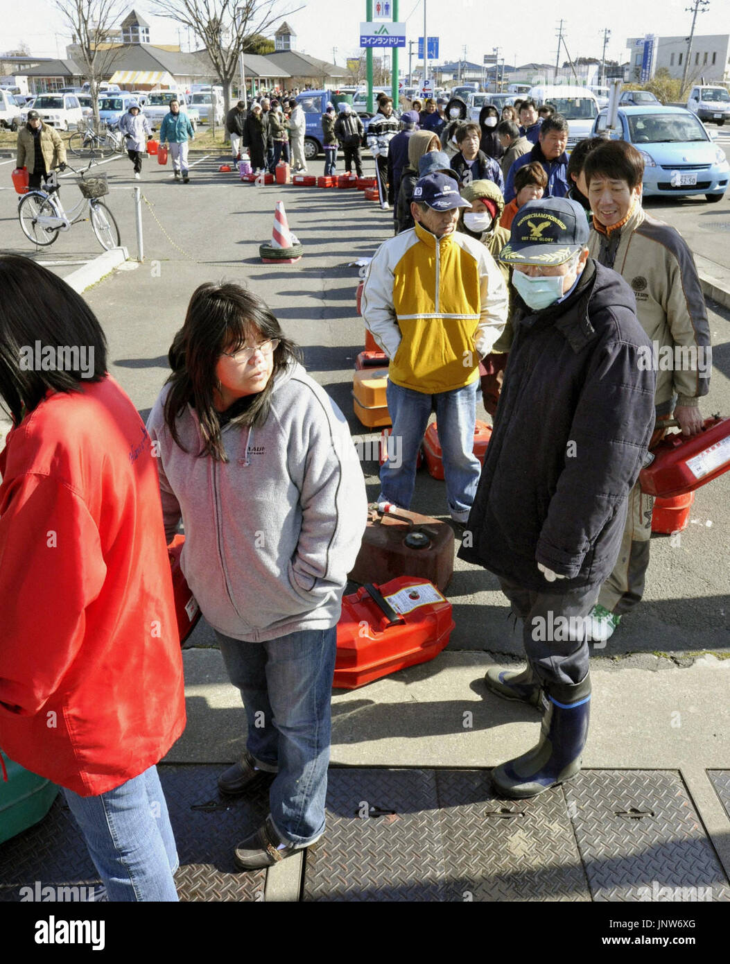 WATARI, Japan - People form a long line to purchase gasoline at a gas ...