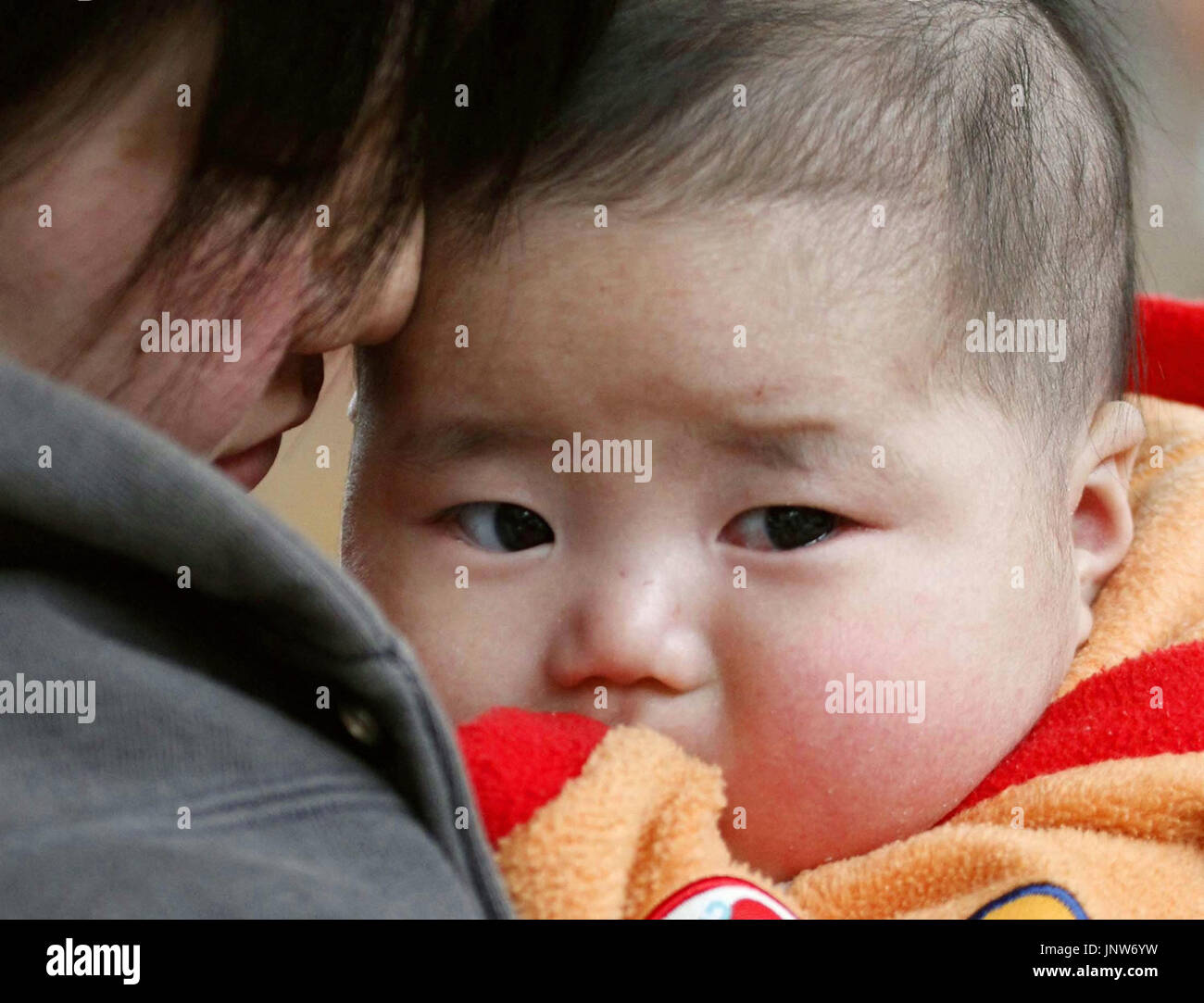 OFUNATO, Japan - A woman holds her infant at an evacuation center in ...