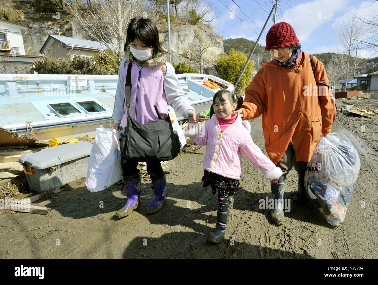HIGASHIMATSUSHIMA, Japan - Members of a family fetch clothing from ...