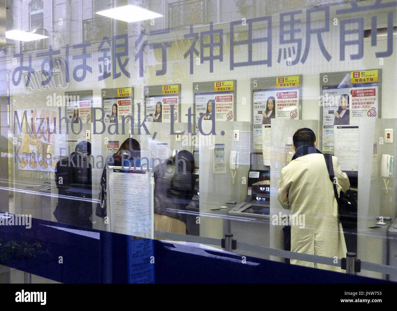 TOKYO, Japan - People use the automated teller machines at a Mizuho ...