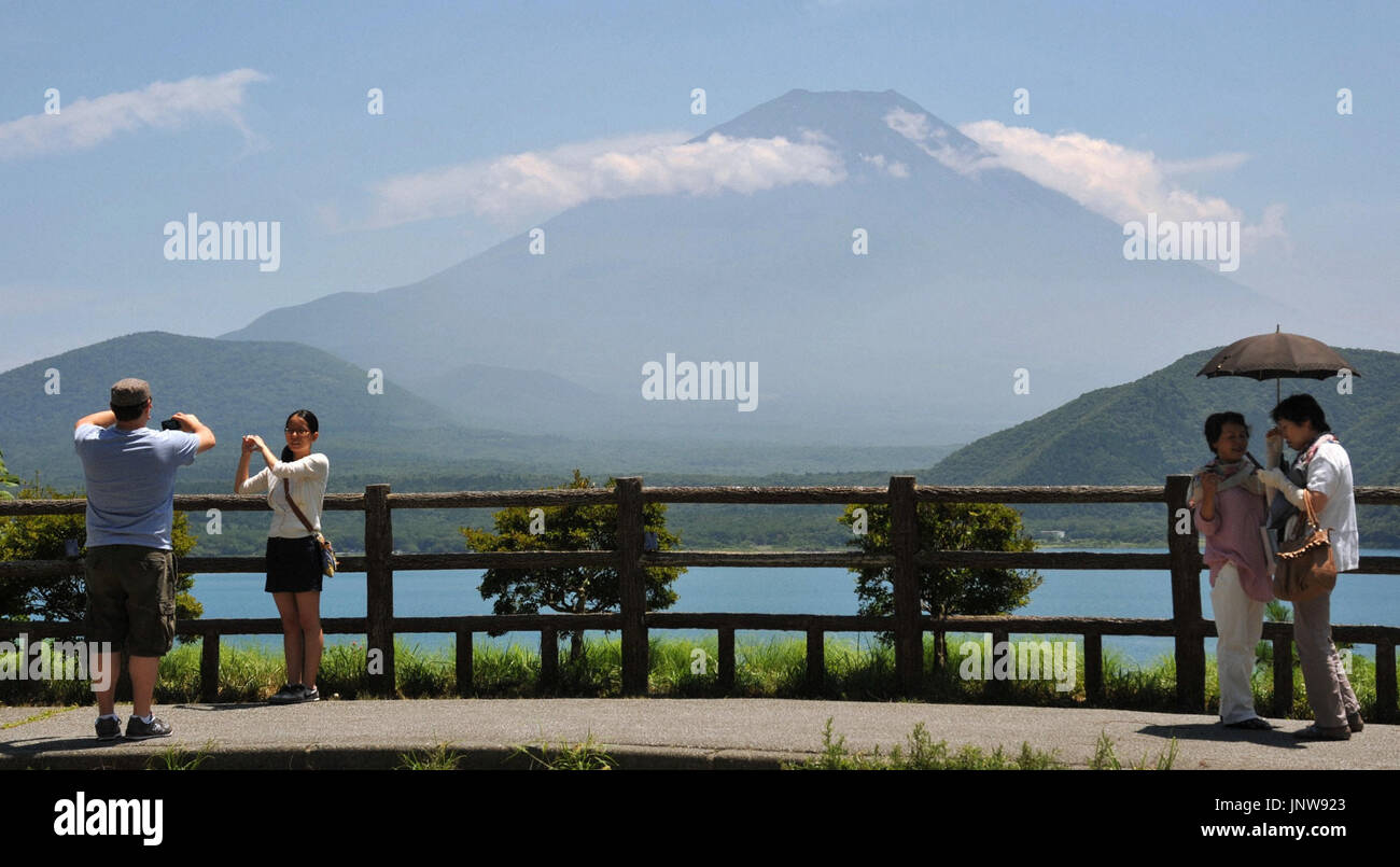 MINOBU, Japan - A tourist (far L) takes pictures of Mt. Fuji at the ...