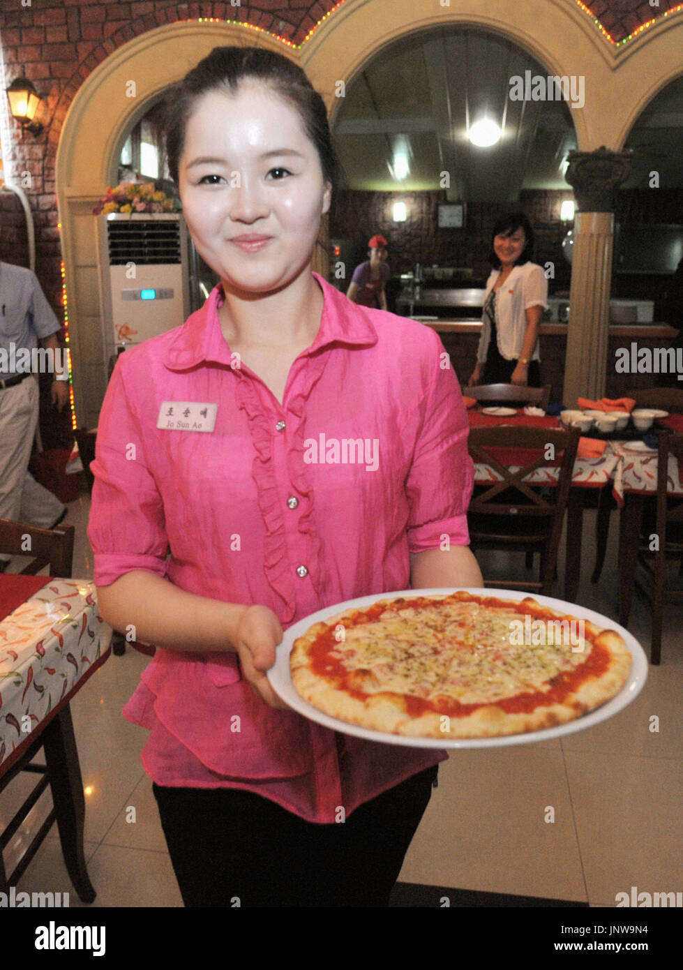 PYONGYANG, North Korea - A waitress carries a pizza in an Italian ...