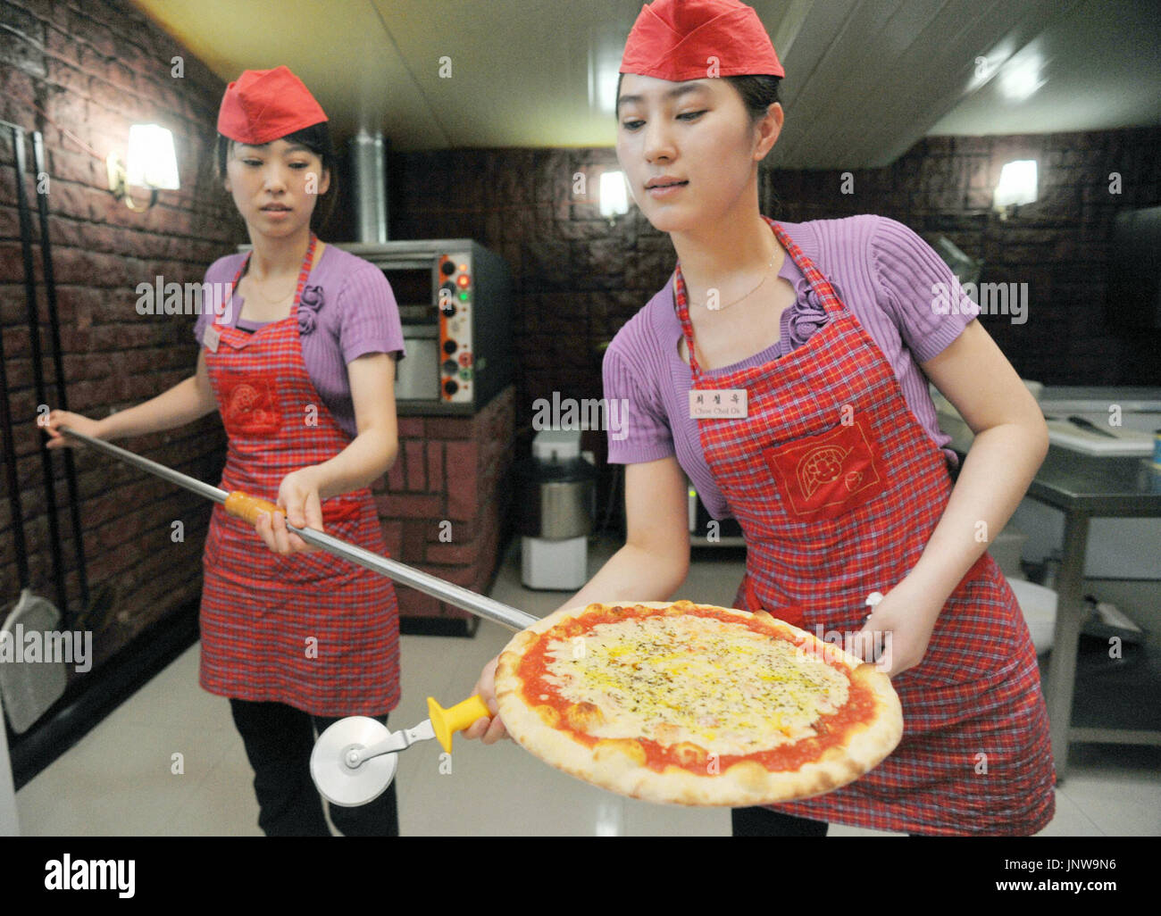 PYONGYANG, North Korea - Female chefs bake a pizza in an Italian ...