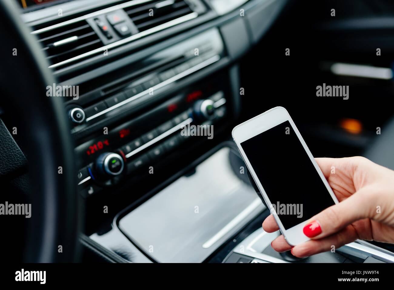 Woman using white smartphone in car. Modern car interior Stock Photo ...
