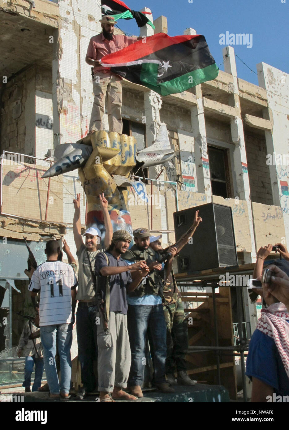 TRIPOLI, Libya - A man climbs on a statue in Muammar Gaddafi's compound ...