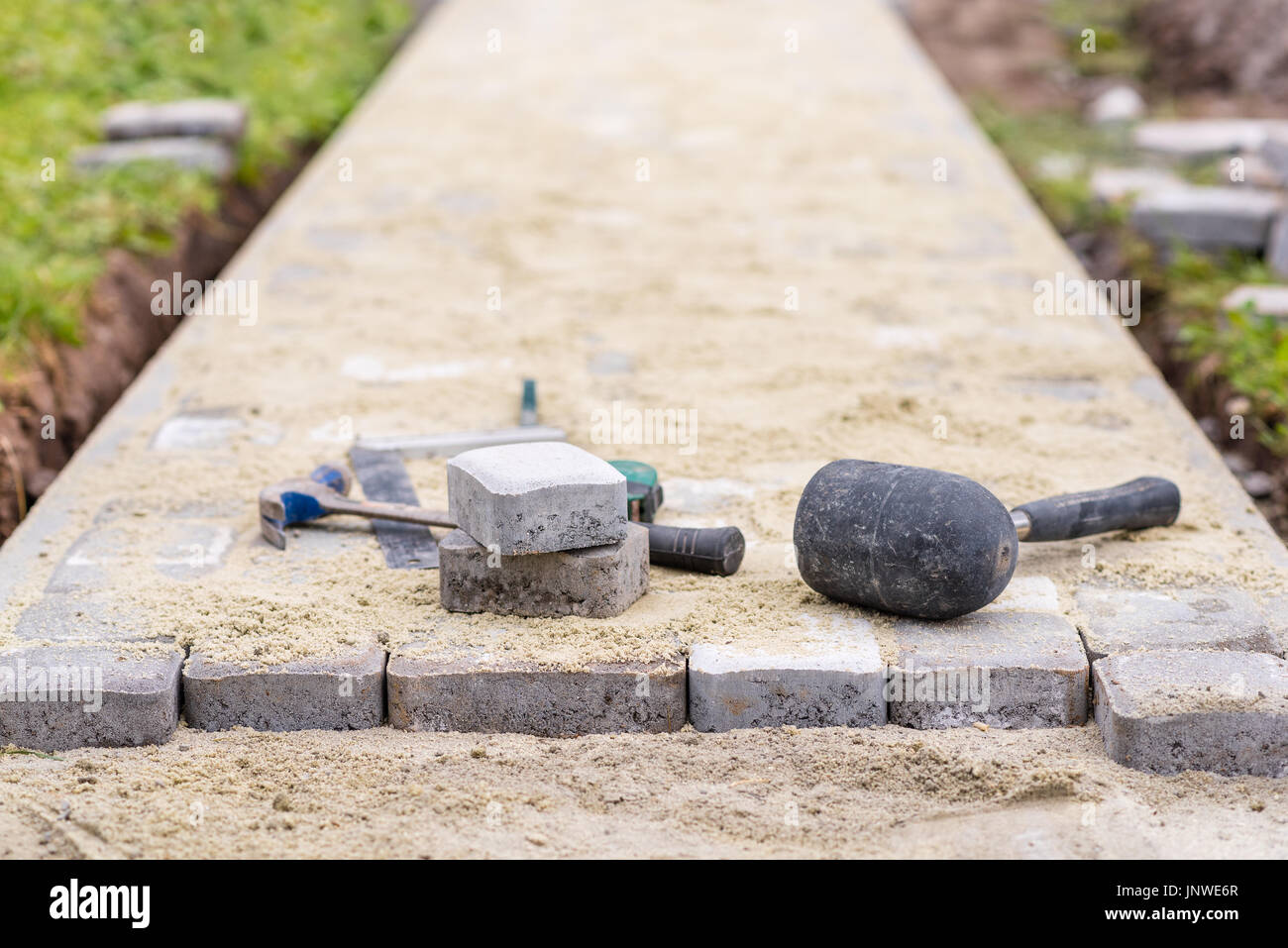Process of laying pavement at yard. Stones are laying on sand. Work ...