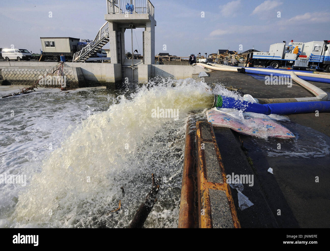 WATARI, Japan - A hose drains floodwater to the sea from the shores of ...