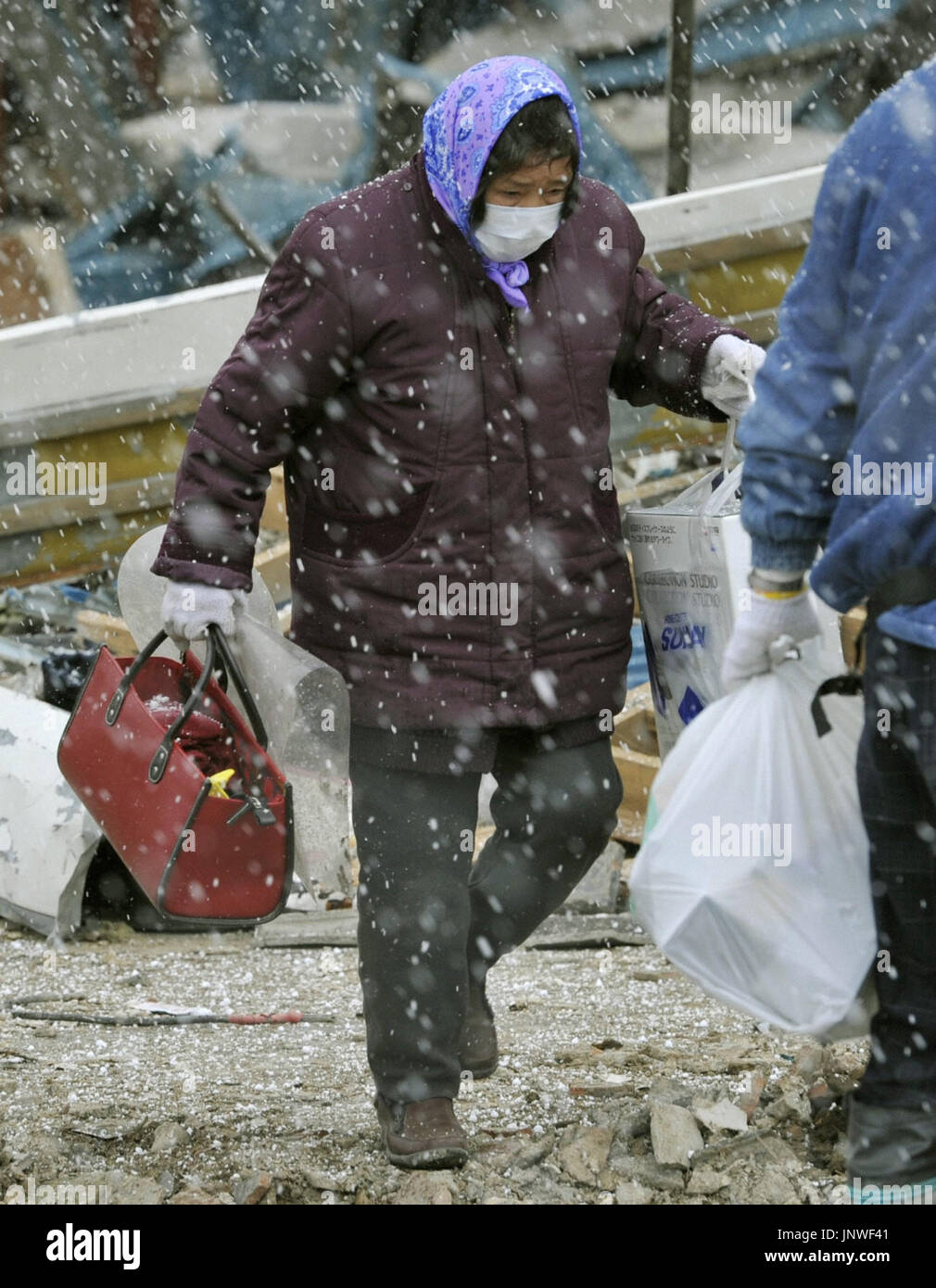 OFUNATO, Japan - An elderly woman carries belongings she retrieved from ...