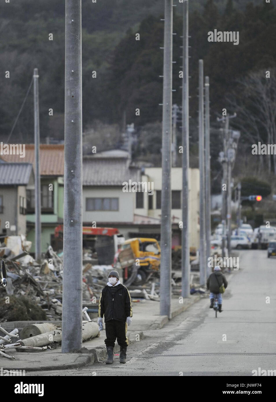 OFUNATO, Japan - A pedestrian passes by new power poles installed in ...