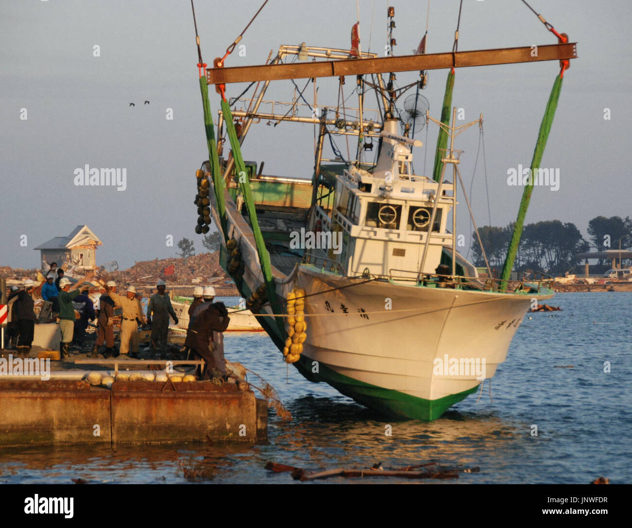 WATARI, Japan - A fishing boat washed ashore by tsunami is lifted by a ...