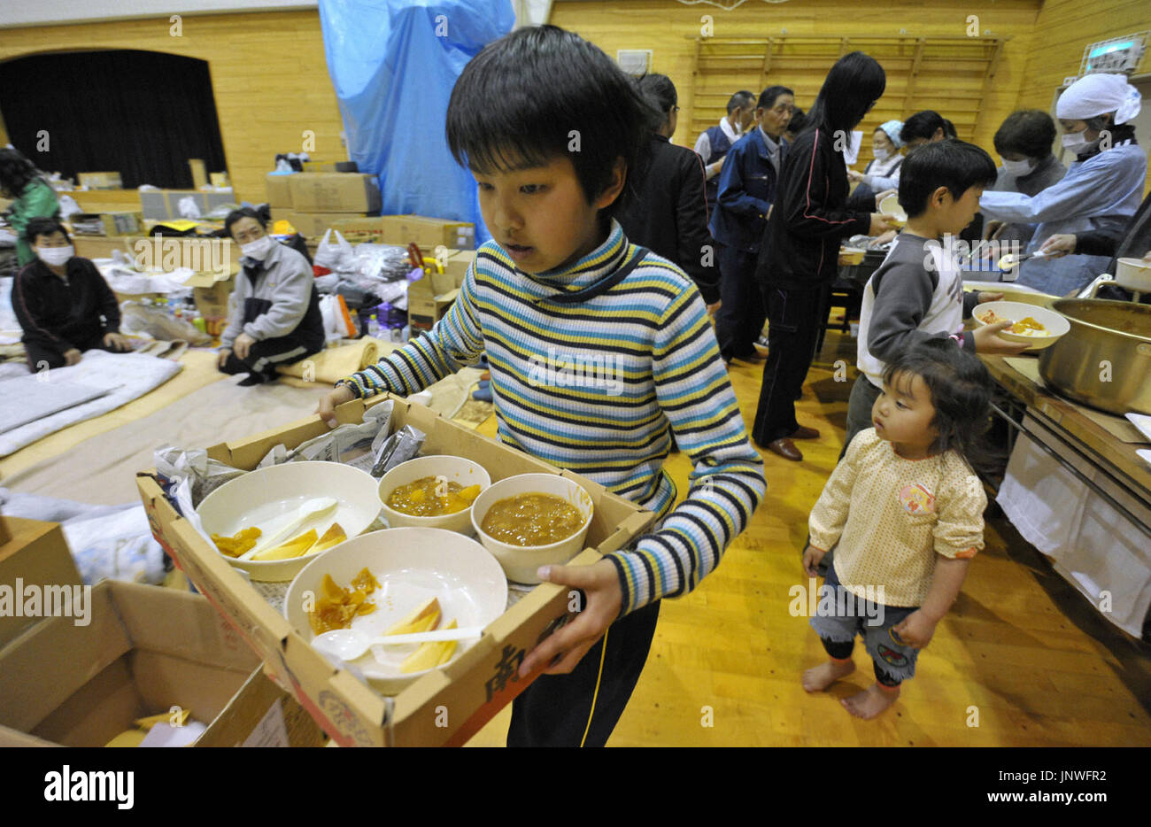 KAWAMATA, Japan - A boy carries dinner dishes using a tray made of ...