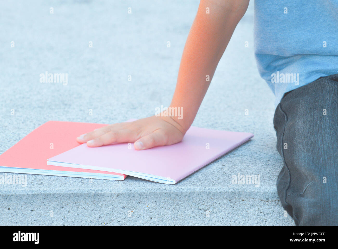 Child's hand and books. Close up Stock Photo - Alamy