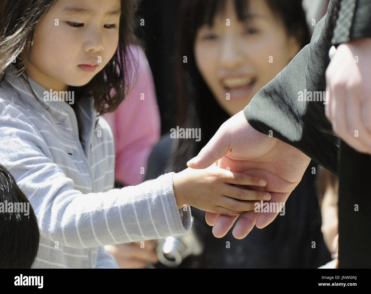 TOKYO, Japan - A girl touches the right hand of Mongolian sumo champion ...