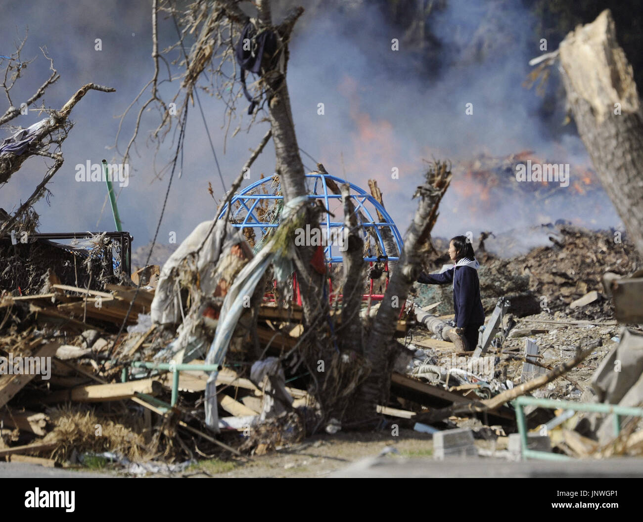 MINAMISANRIKU, Japan - A woman rotates playground equipment in rubble ...