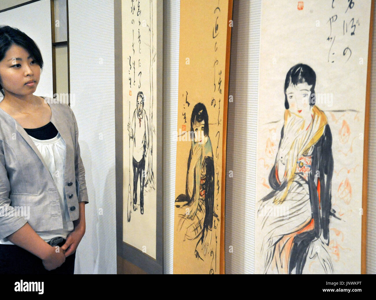 KYOTO, Japan - A woman looks at three paintings by renowned Japanese ...