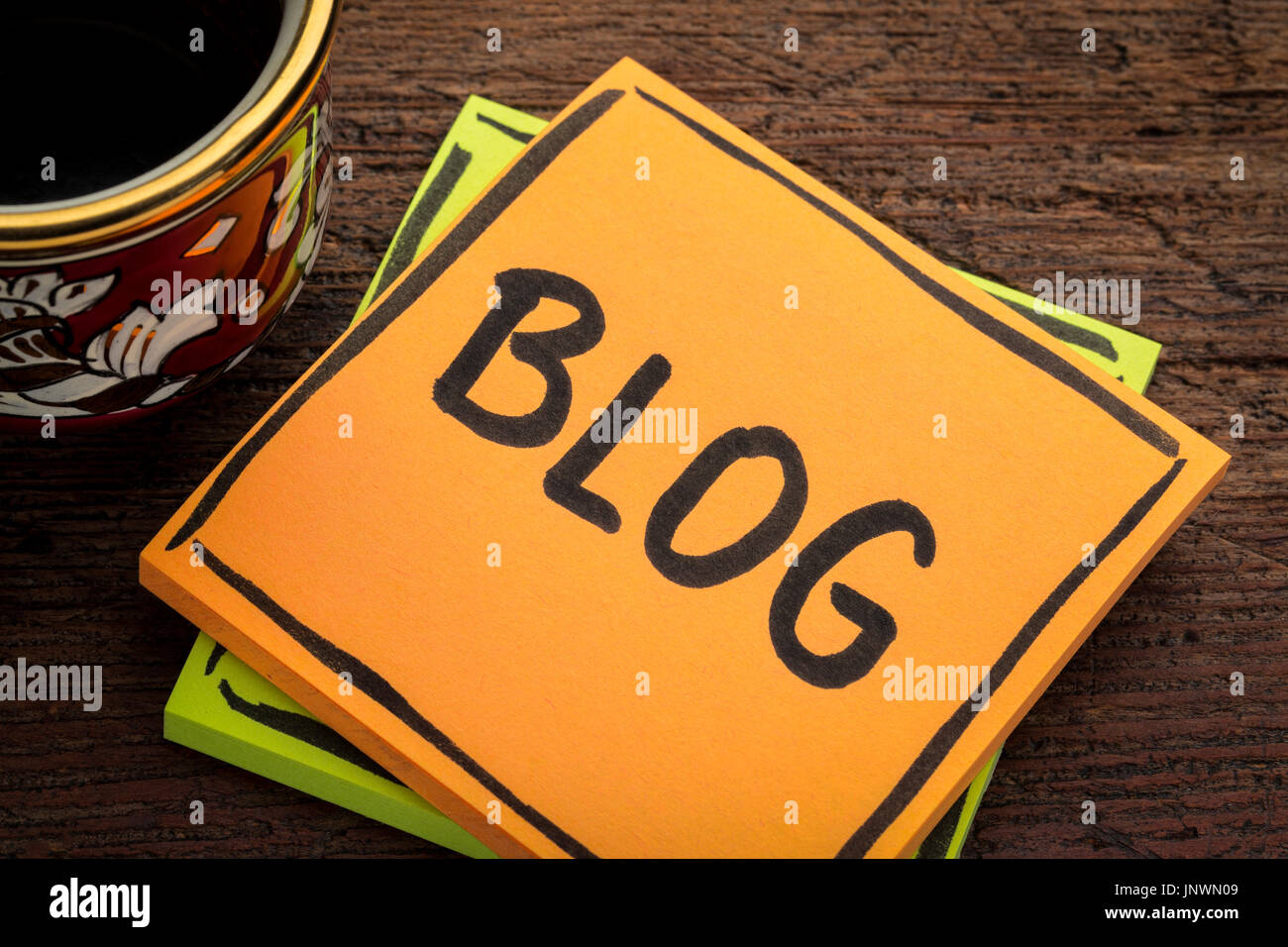 blog reminder - handwriting in black ink on a sticky note with a cup of ...