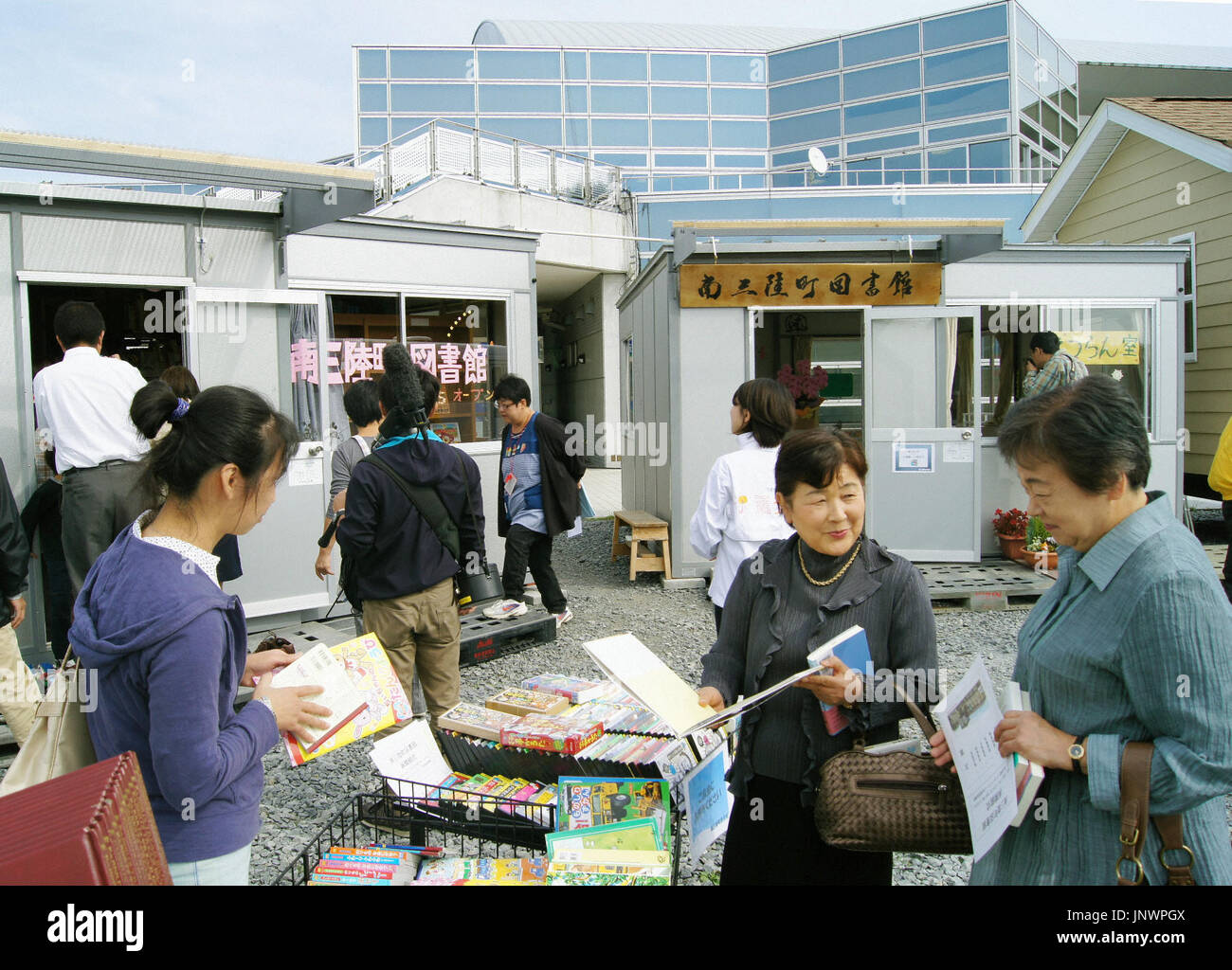 MINAMISANRIKU, Japan - People visit a makeshift public library in the ...