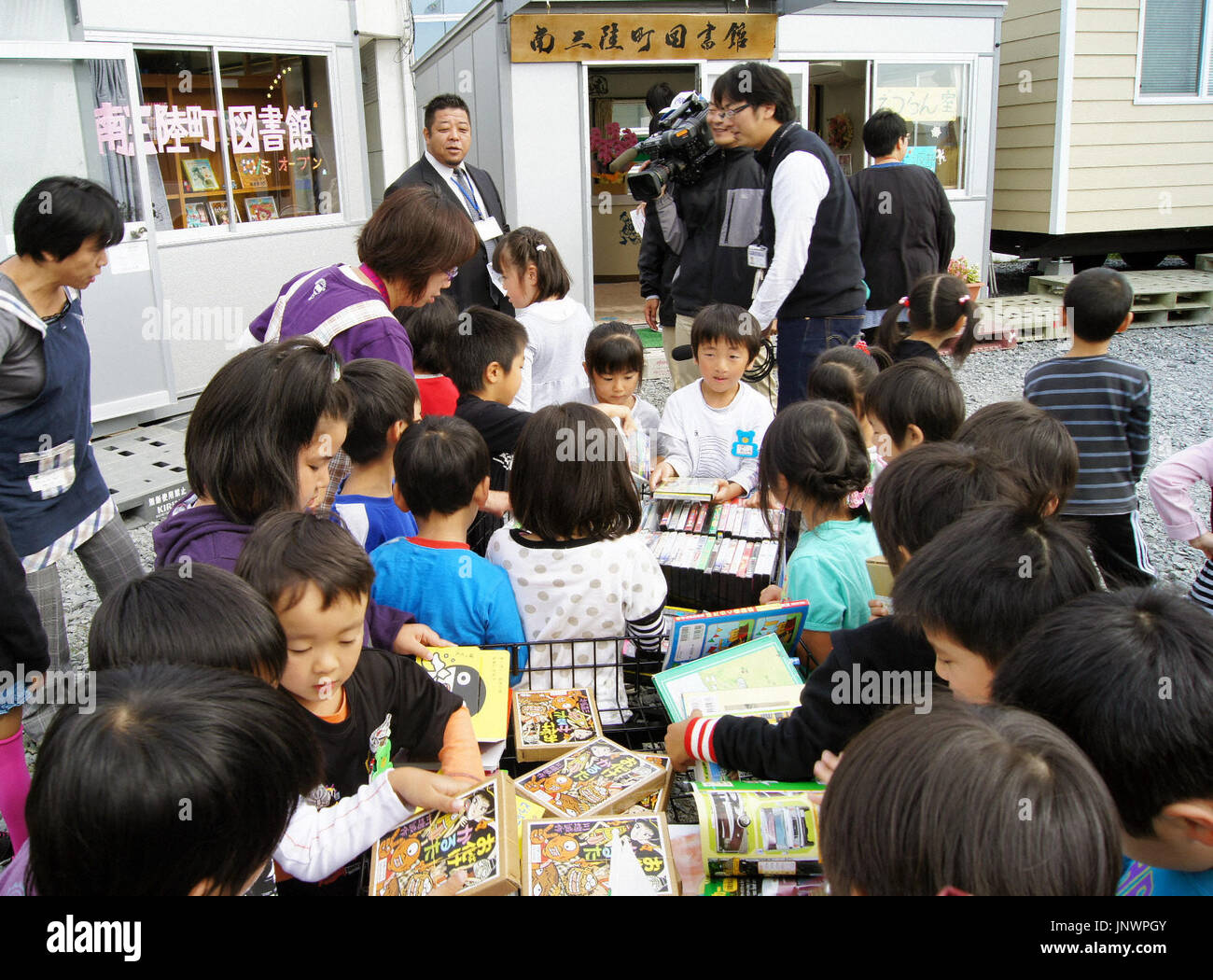 MINAMISANRIKU, Japan - Children visit a makeshift public library in the ...