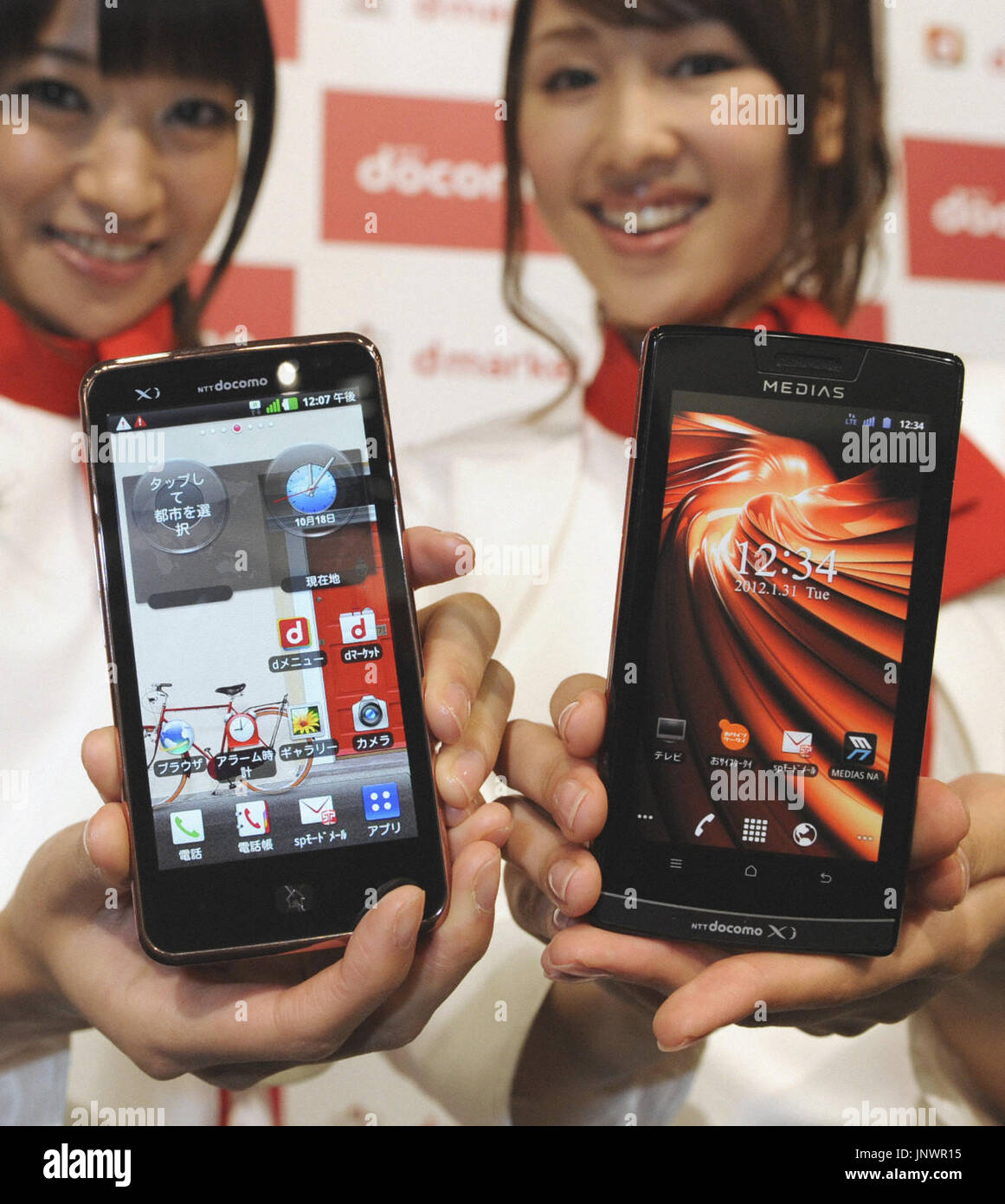 TOKYO, Japan - Women hold NTT Docomo Inc.'s Android-based smartphone ...
