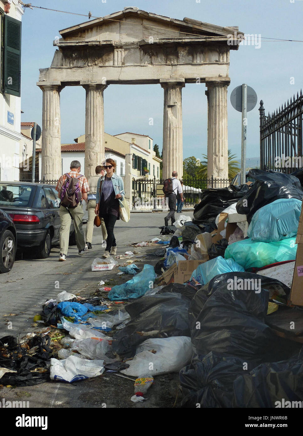 ATHENS, Greece - People walk by piles of garbage in a street of Athens ...