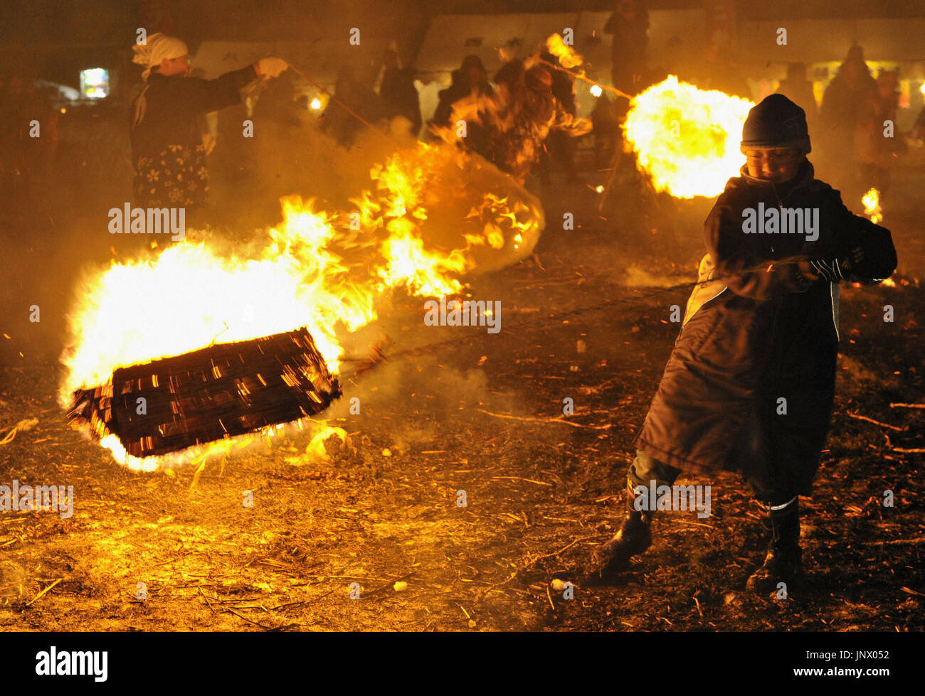 SEMBOKU, Japan - A child swings a sack of burning coals tied to a rope ...