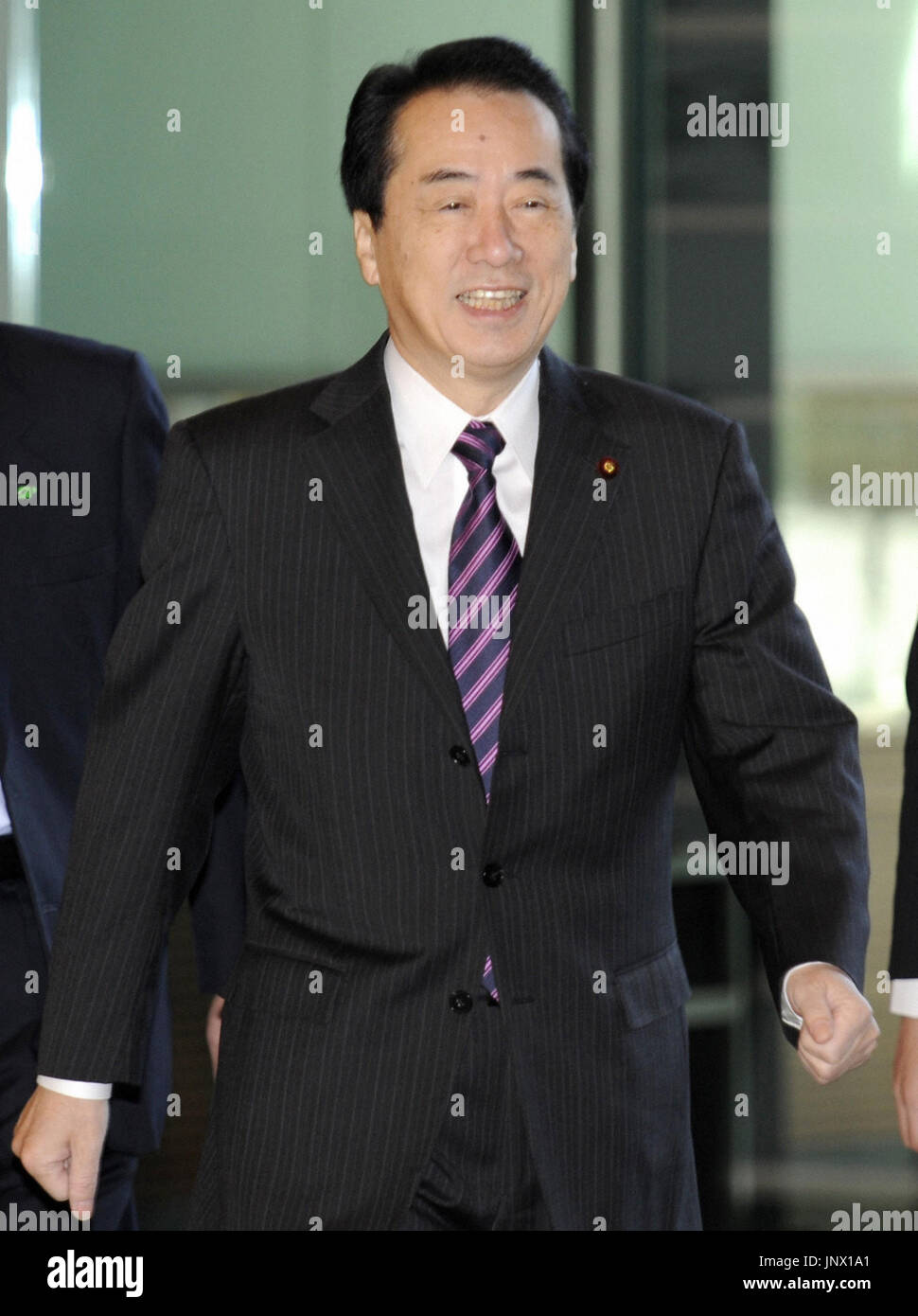 TOKYO, Japan - Prime Minister Naoto Kan smiles as he enters his office ...