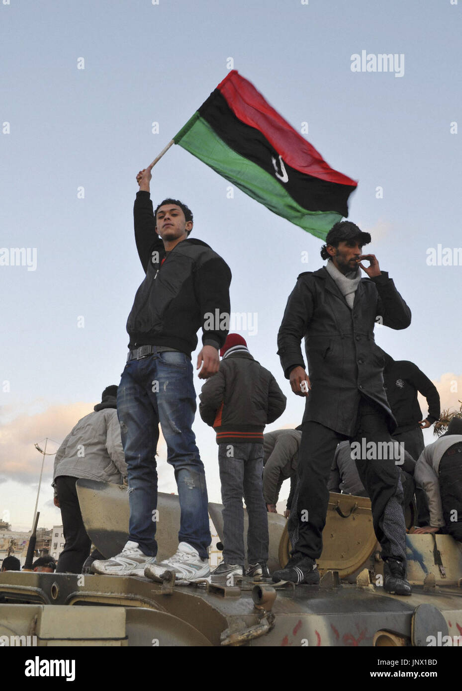 TOBRUK, Libya - A young man holds up a Kingdom of Libya flag in ...