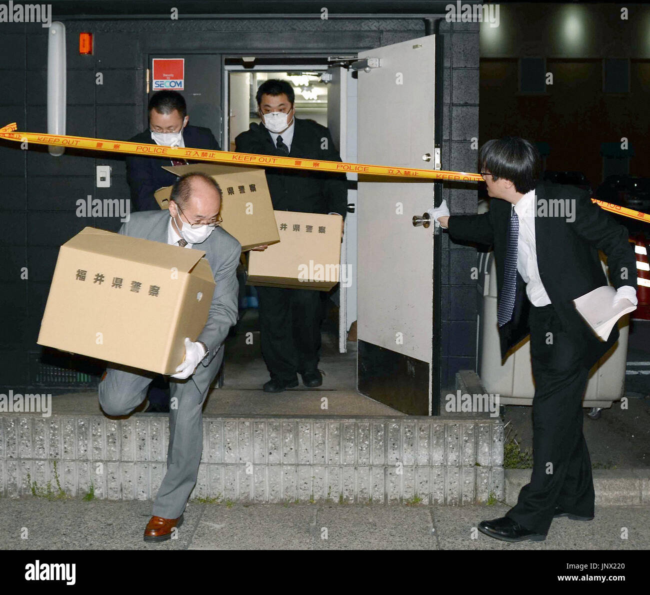 FUKUI, Japan - Police investigators bring out boxes of confiscated ...