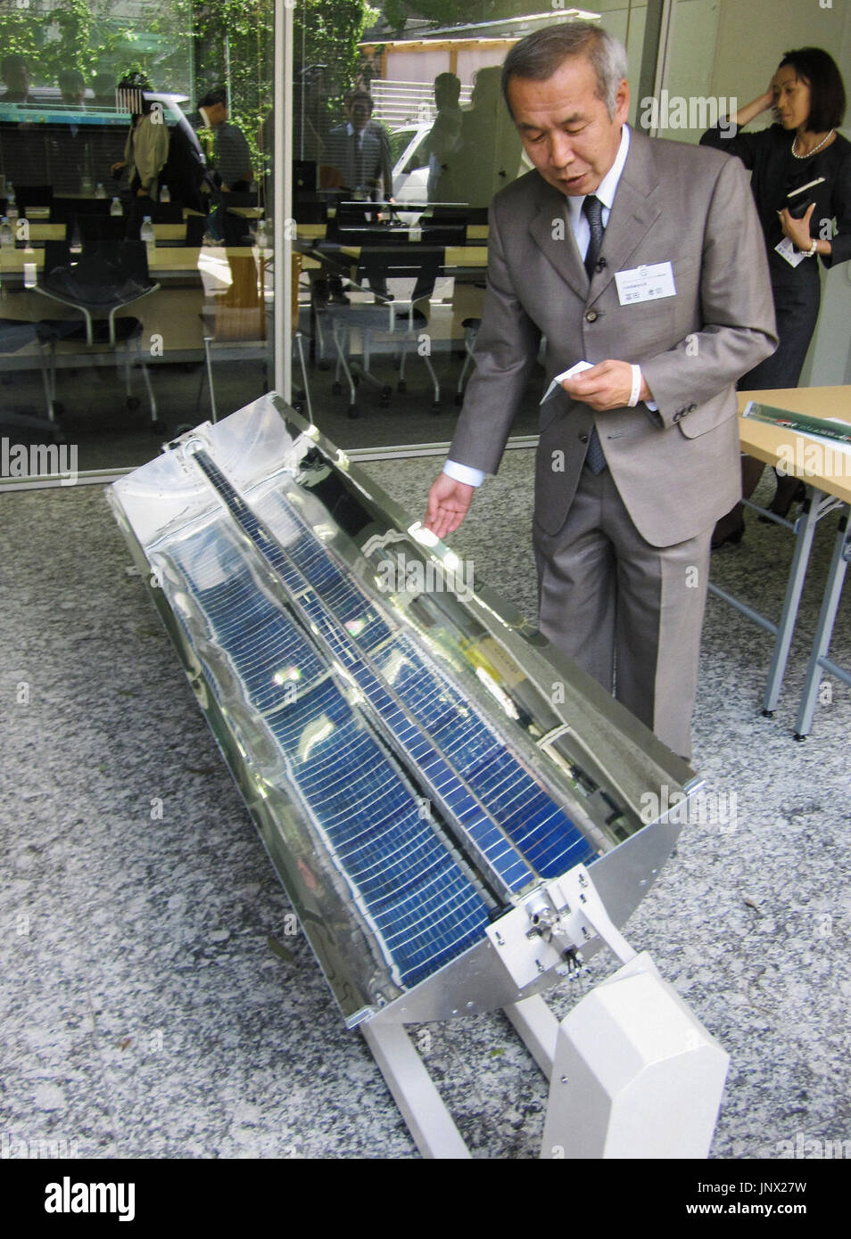 TOKYO, Japan - A man shows a low-cost solar power system developed by ...