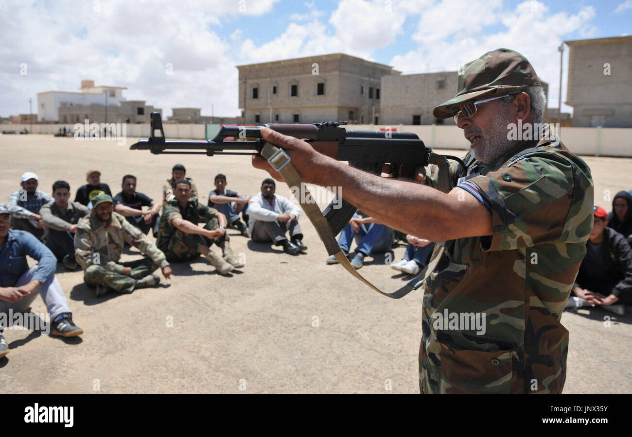 BENGHAZI, Libya - An instructor shows how to use a gun before men ...