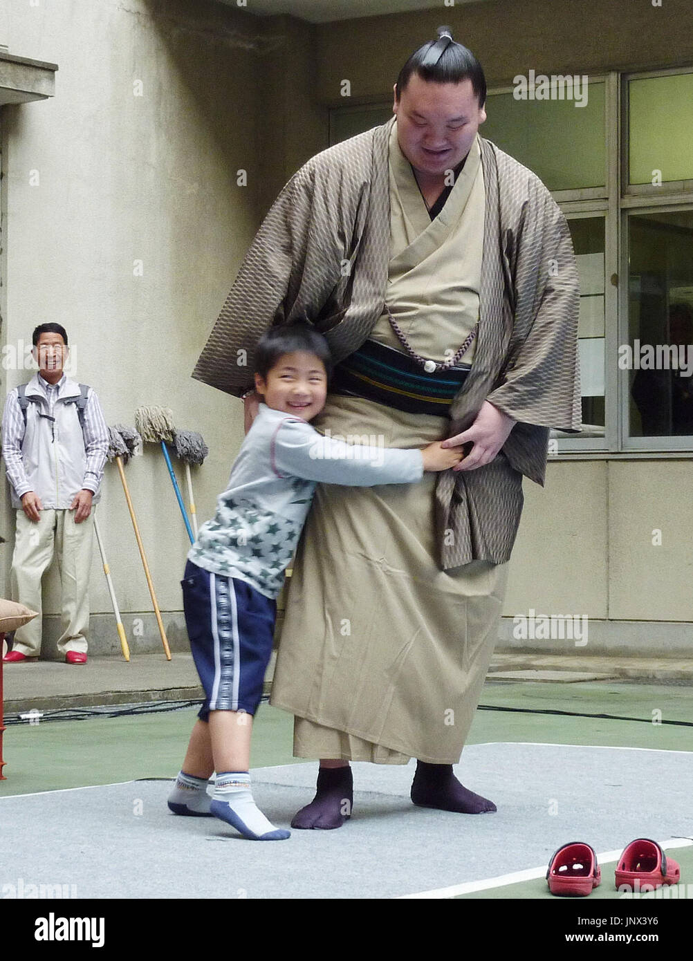 SAITAMA, Japan - Grand champion Hakuho plays with a child during a ...