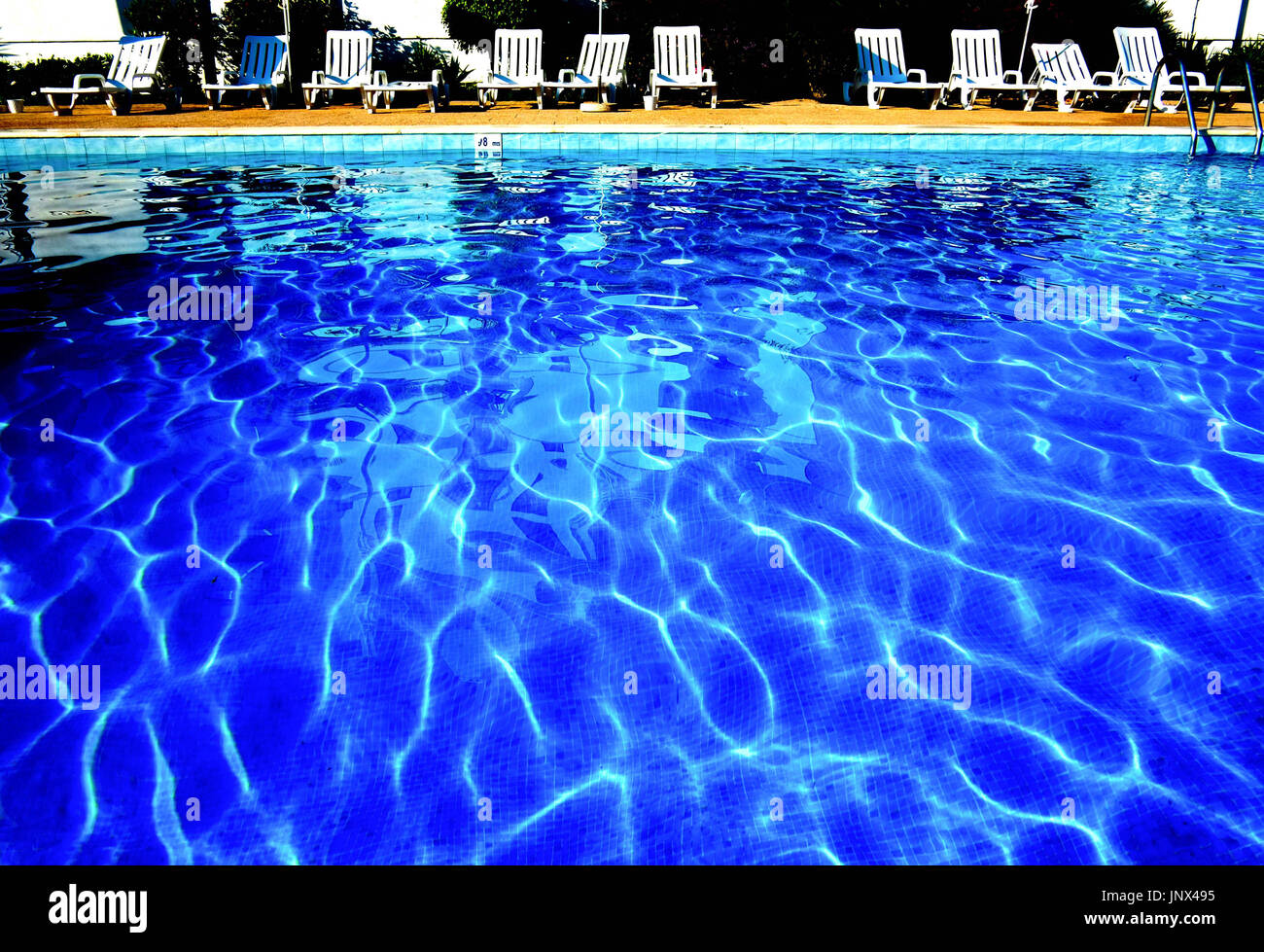 Blue water in a swimming pool, the water is rippled and transparent and ...