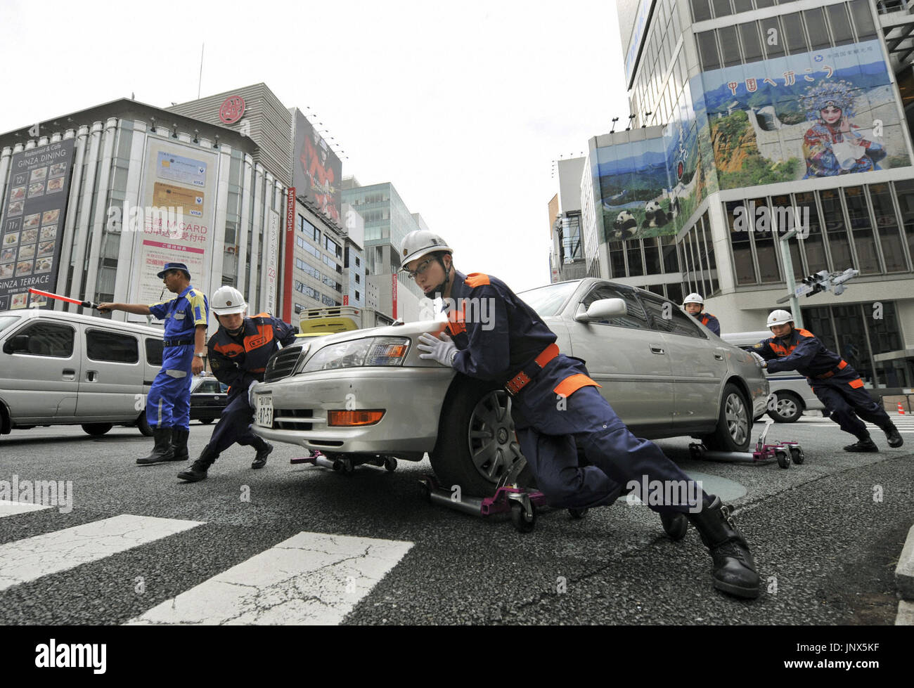 TOKYO, Japan - Police officers move a car in the Ginza shopping ...