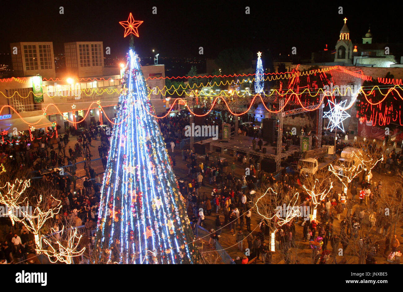 BETHLEHEM, West Bank - People gather around a Christmas tree in a ...
