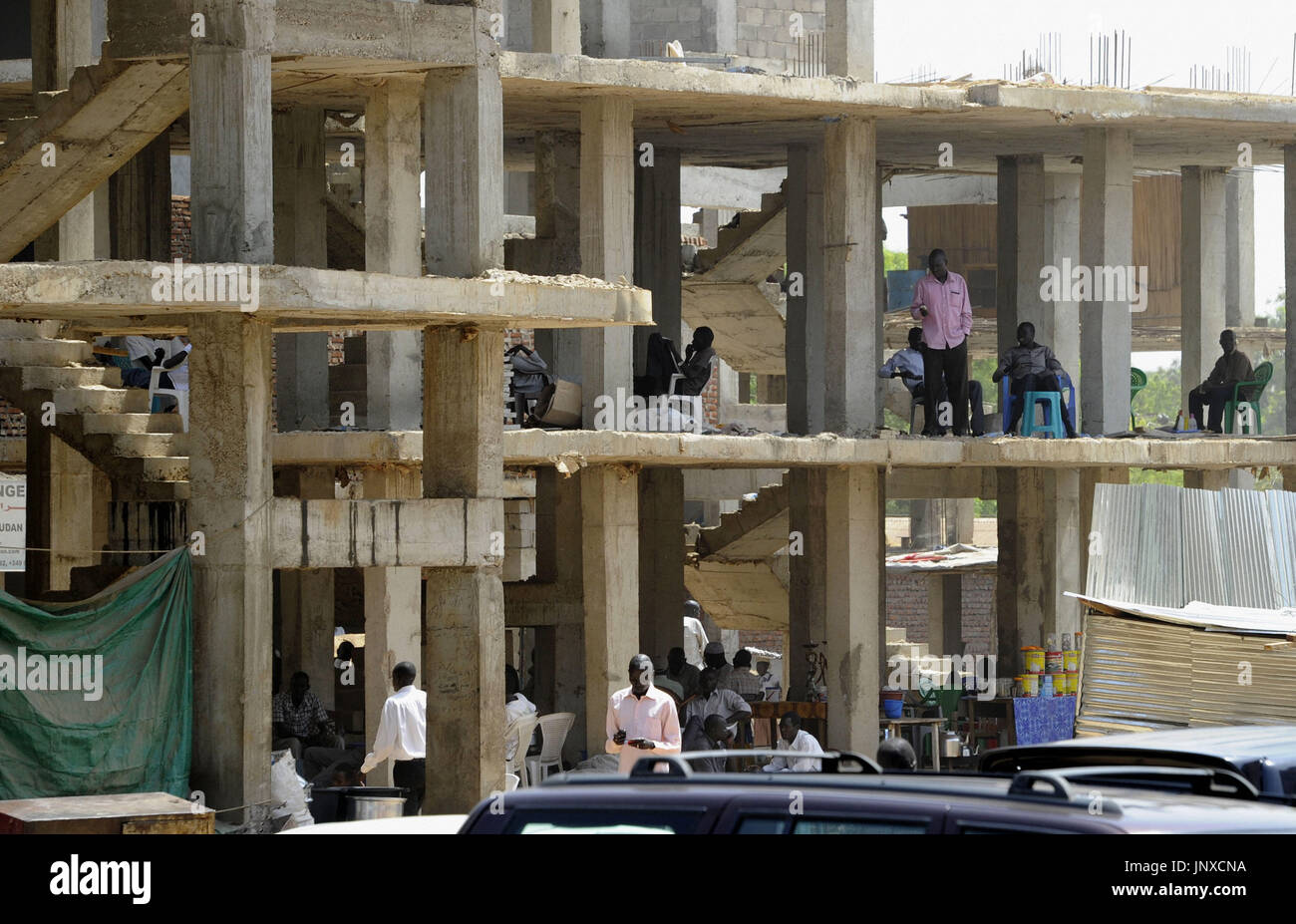 JUBA, South Sudan - People are pictured in and around a building under ...
