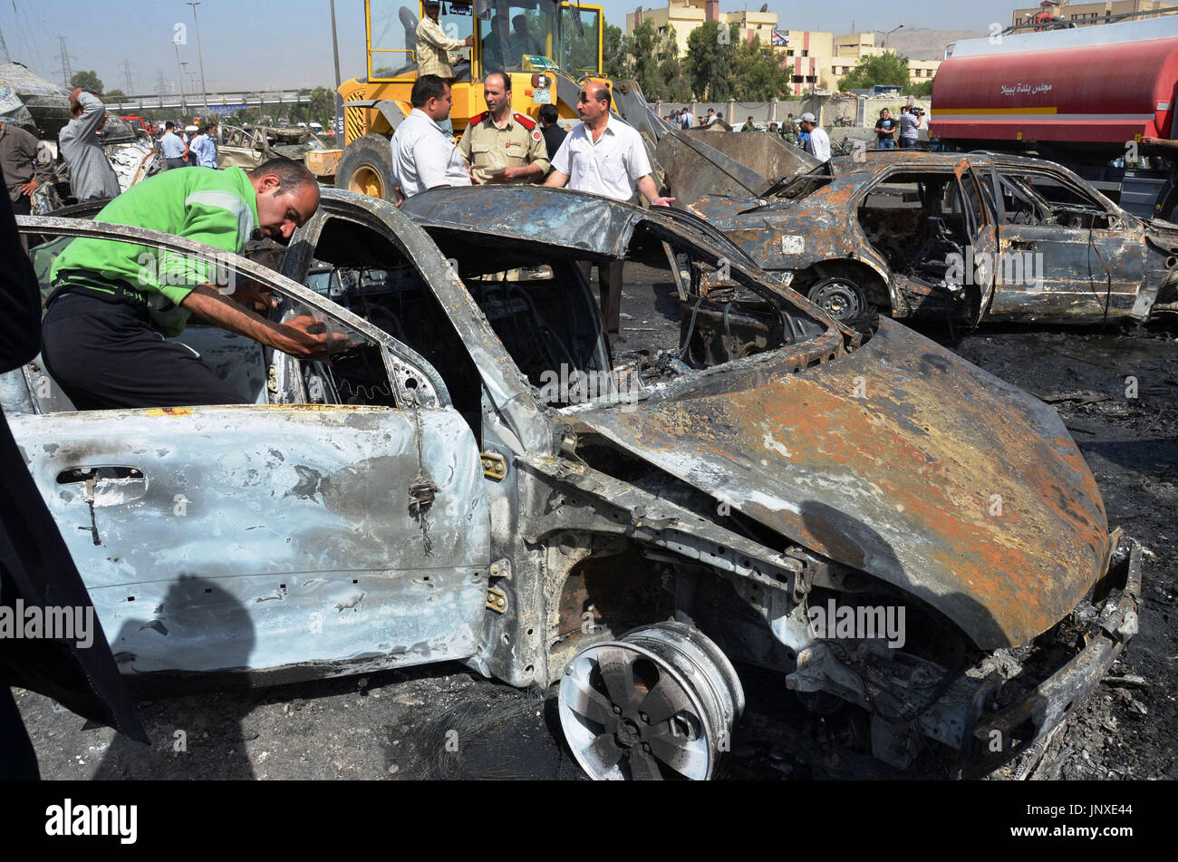 DAMASCUS, Syria - Security officials examine cars burned by suicide ...