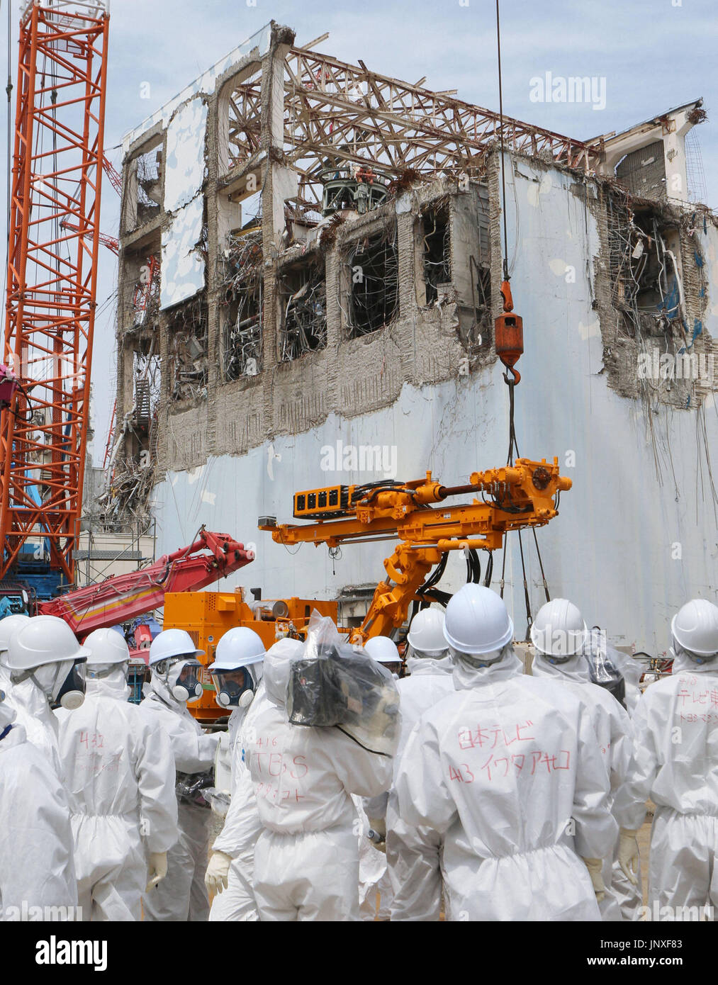 TOKYO, Japan - A group of reporters view the wrecked reactor building ...