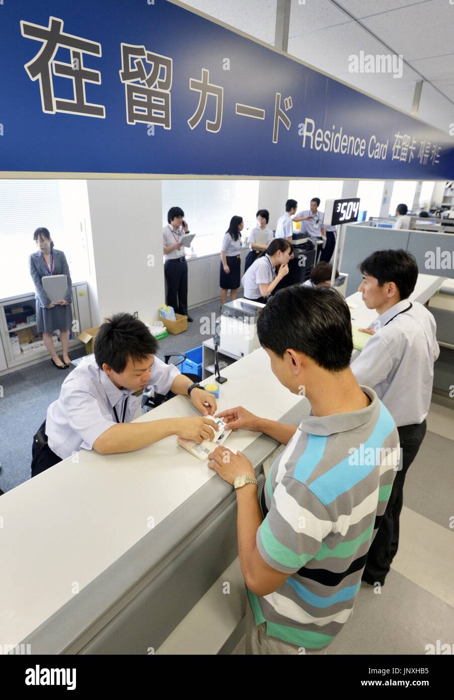 OSAKA, Japan - Foreigners receive new residence cards at the Osaka ...